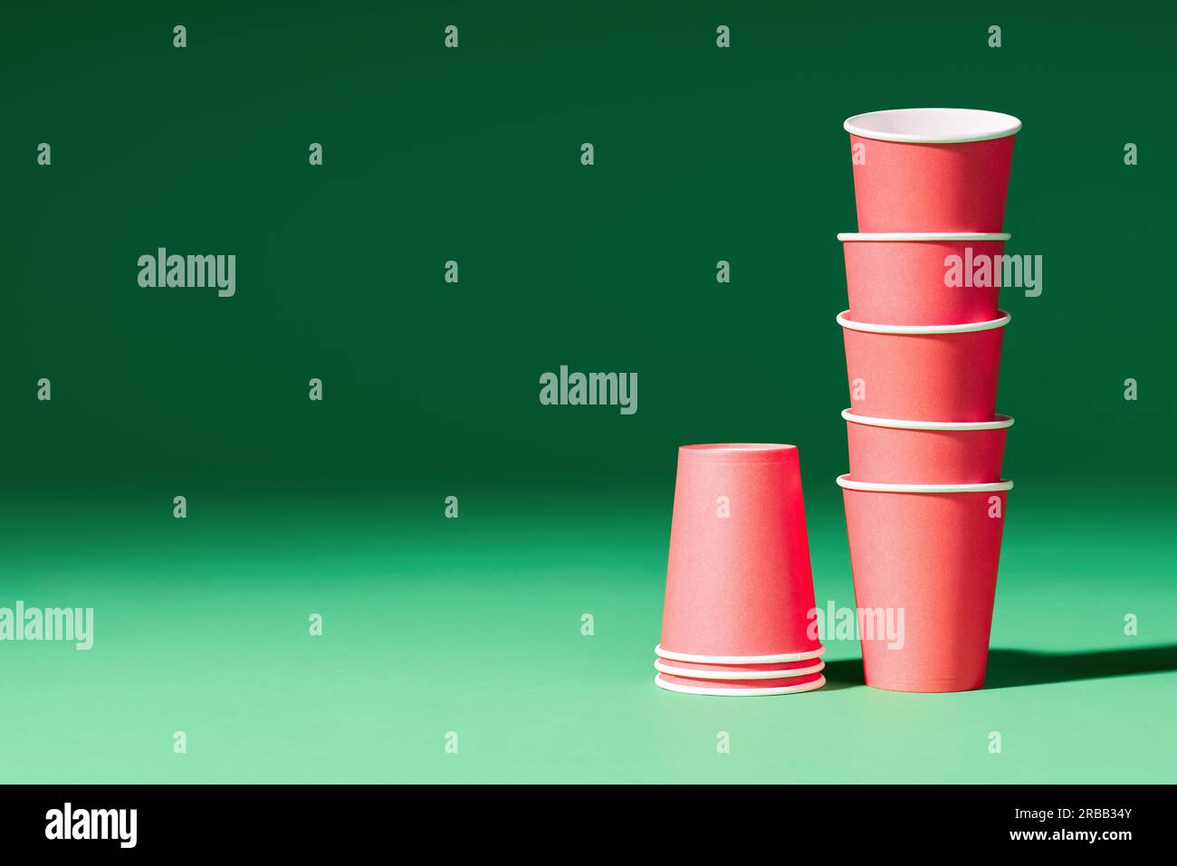 Set of red paper cups on green background with copy space. Zero waste ...
