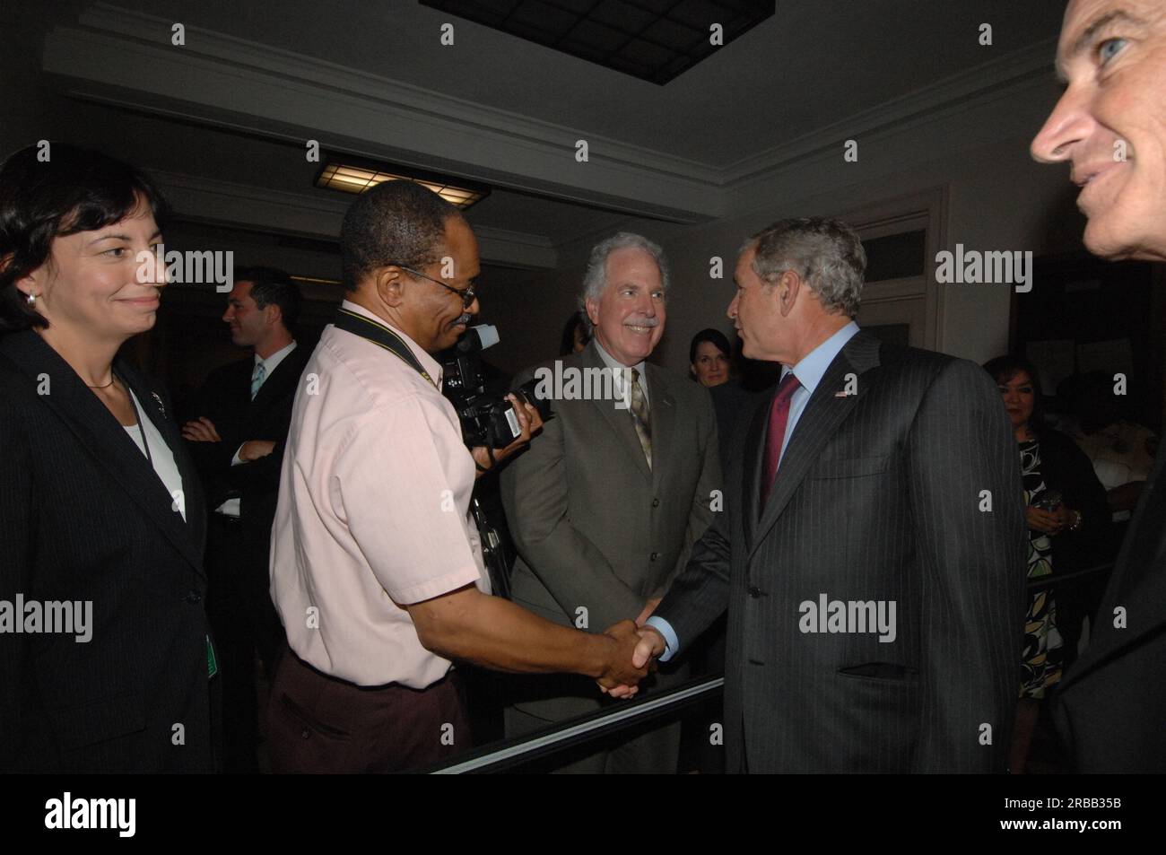 Department staff greeting President George W. Bush, from behind rope ...