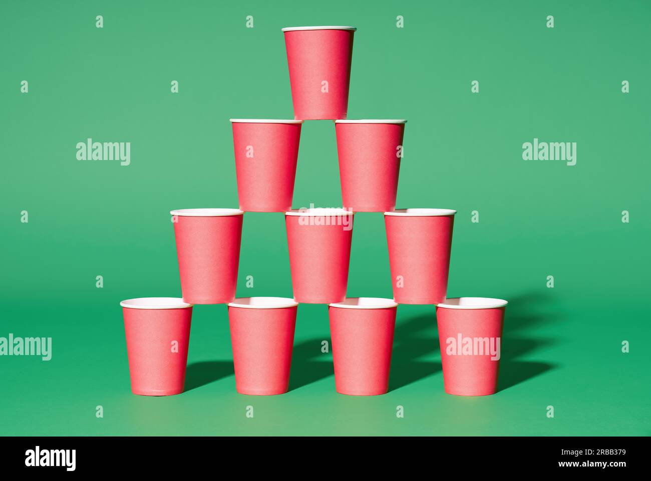 Pyramid of red paper cups on green background. minimalism concept Stock ...