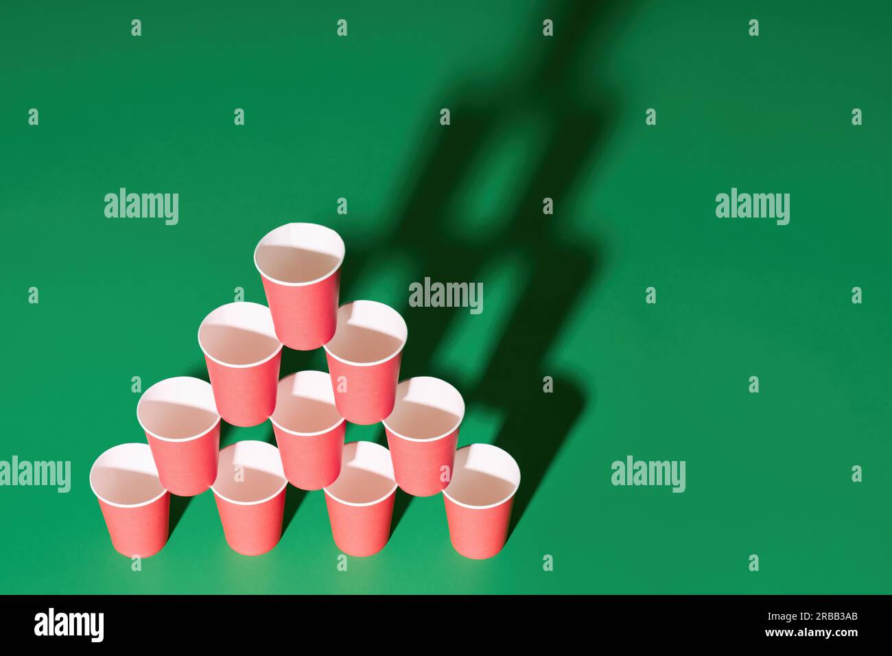 Pyramid of red paper cups on green background with copy space ...