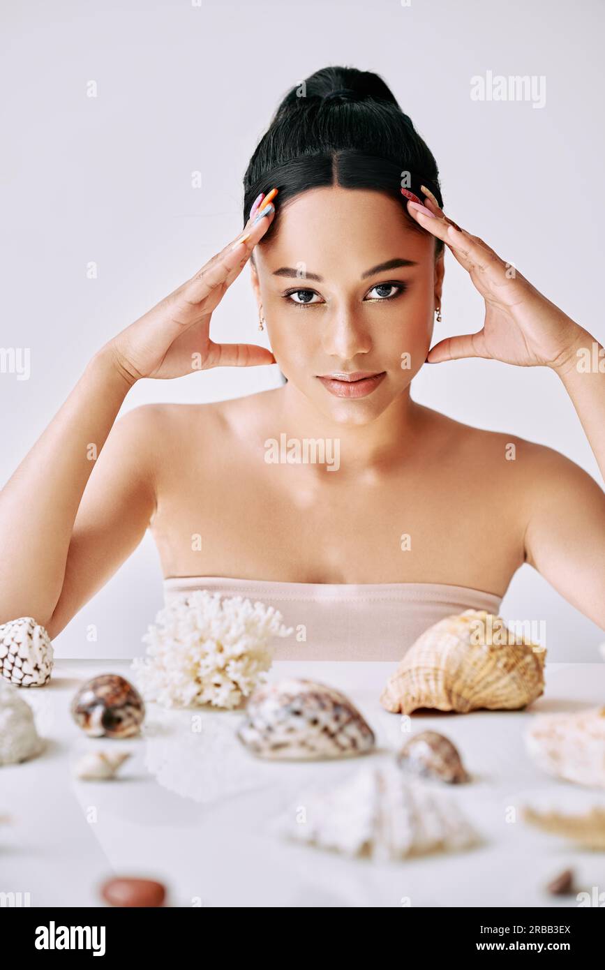 Smiling pretty afro woman with different seashells on white background ...