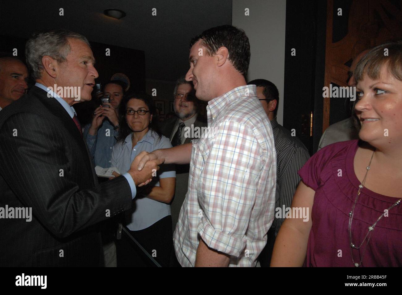 Department staff greeting President George W. Bush, from behind rope ...
