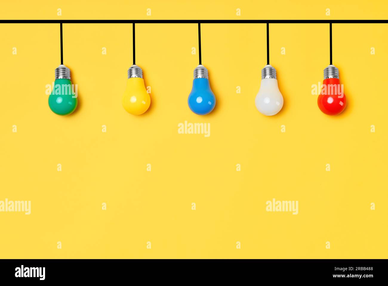 Creative layout with multicolored lightbulbs on yellow background with ...