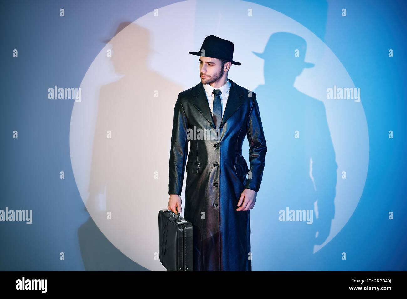 Handsome man in black coat and hat holding briefcase posing in the ...