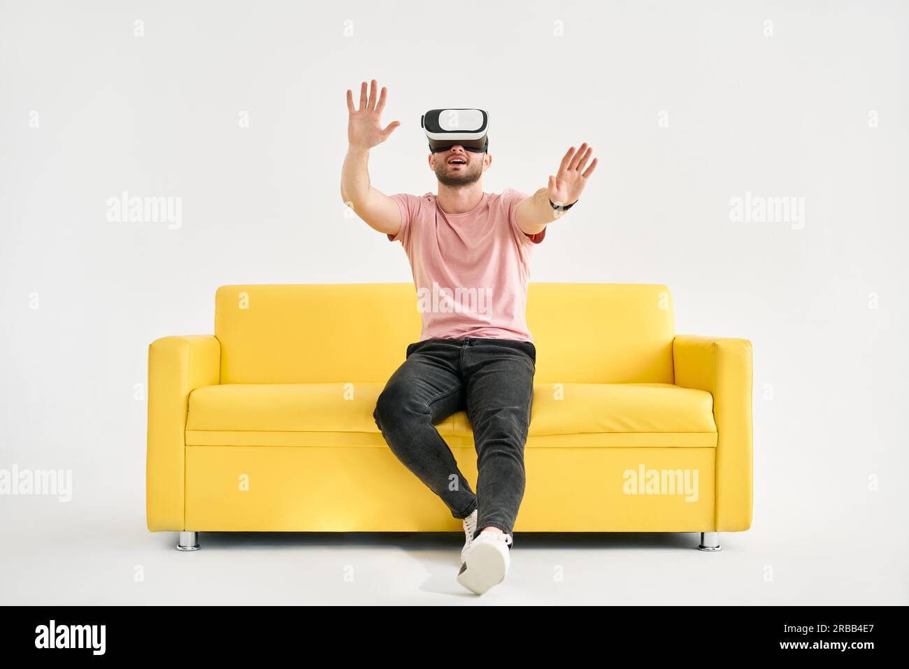 Young man wearing virtual reality headset playing video games and ...