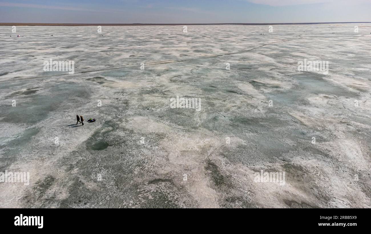 Aerial of fisherman walking on lake Tengiz, Korgalzhyn Nature Reserve ...