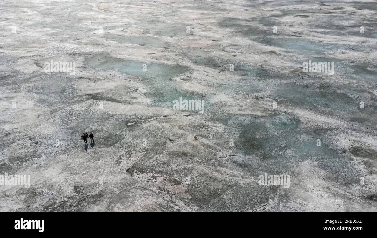 Aerial of fisherman walking on lake Tengiz, Korgalzhyn Nature Reserve ...