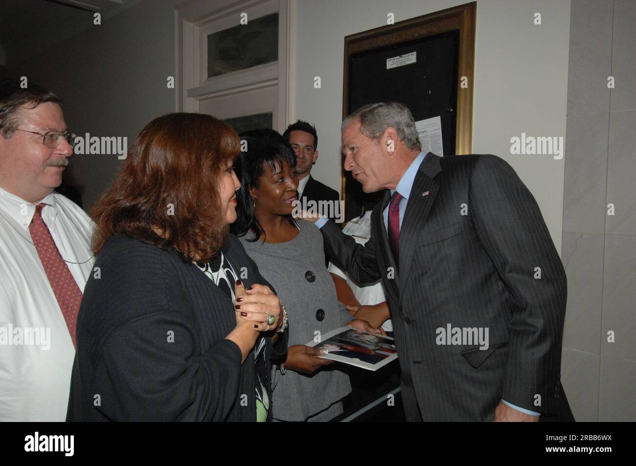 Department staff greeting President George W. Bush, from behind rope ...