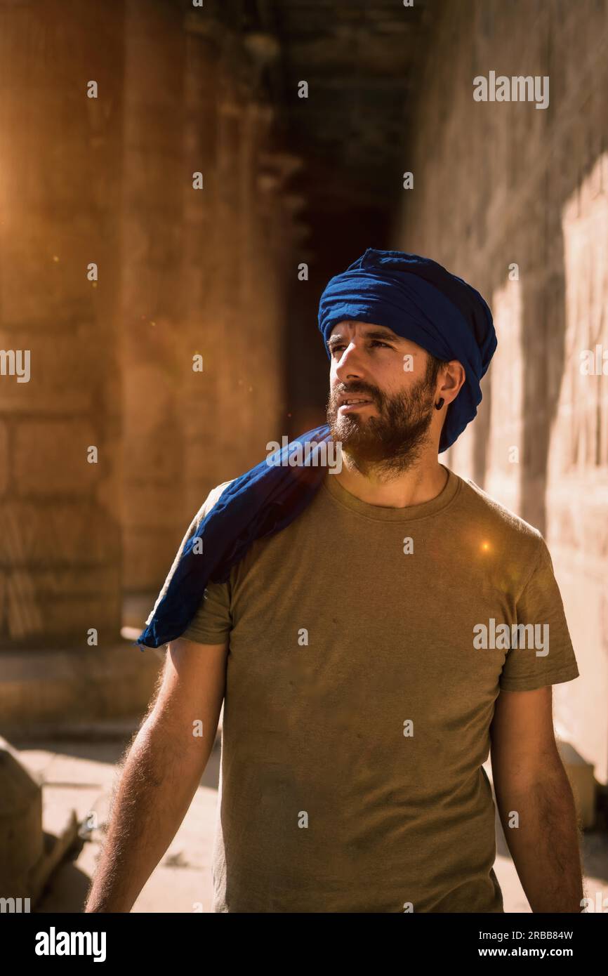 Young man in blue turban walking on the columns of the Edfu Temple near ...