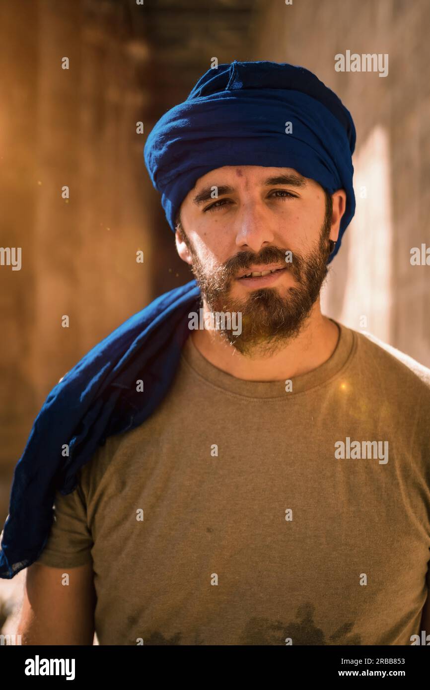 Young man in blue turban walking on the columns of the Edfu Temple near ...