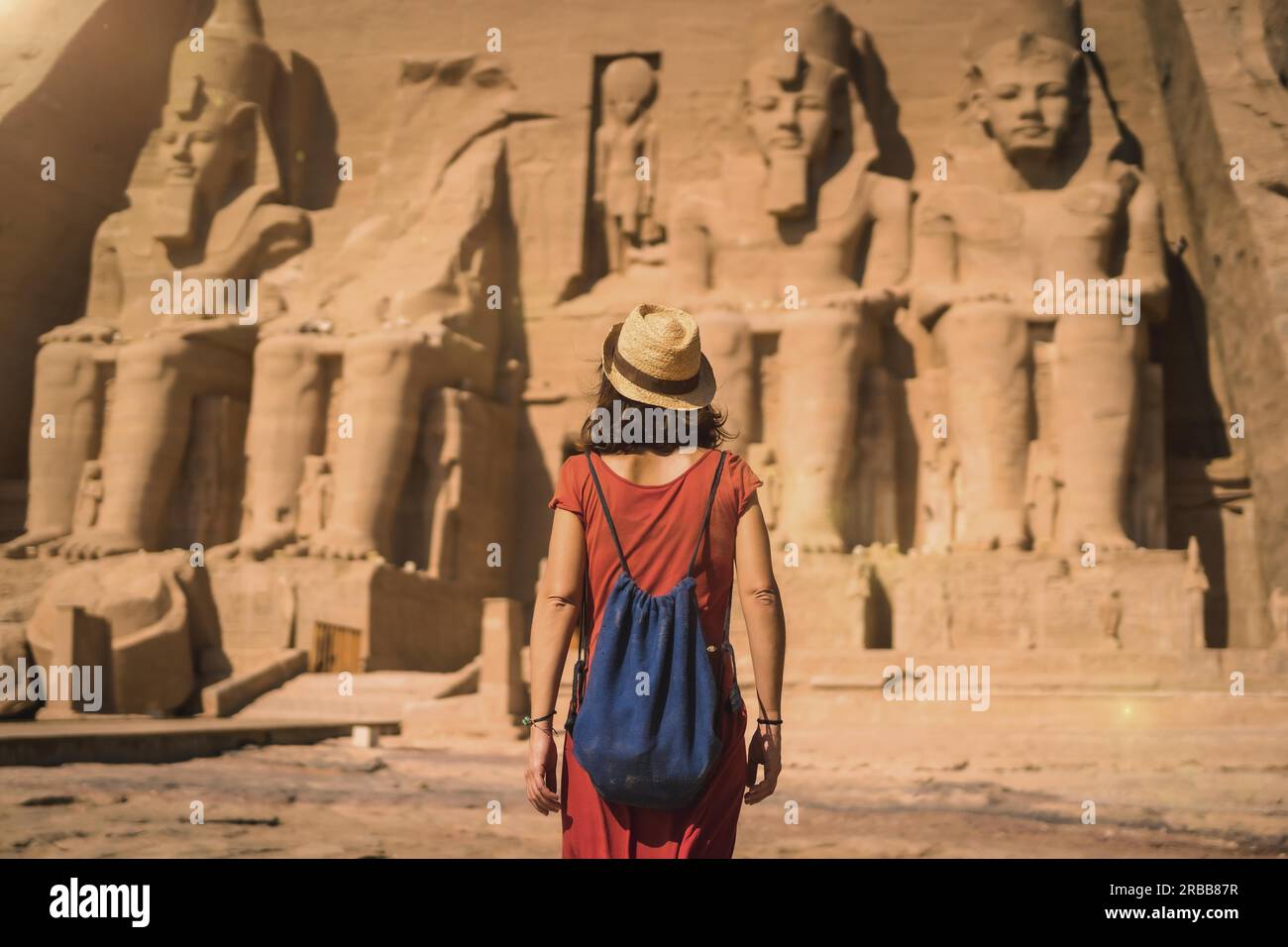A young tourist in a red dress entering the Abu Simbel Temple in ...