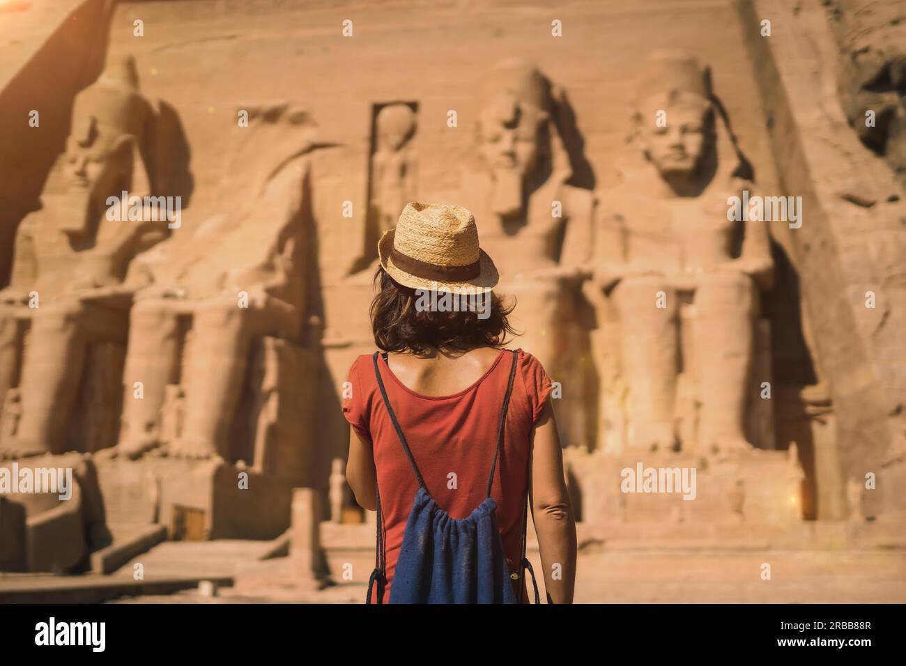 A young tourist in a red dress entering the Abu Simbel Temple in ...
