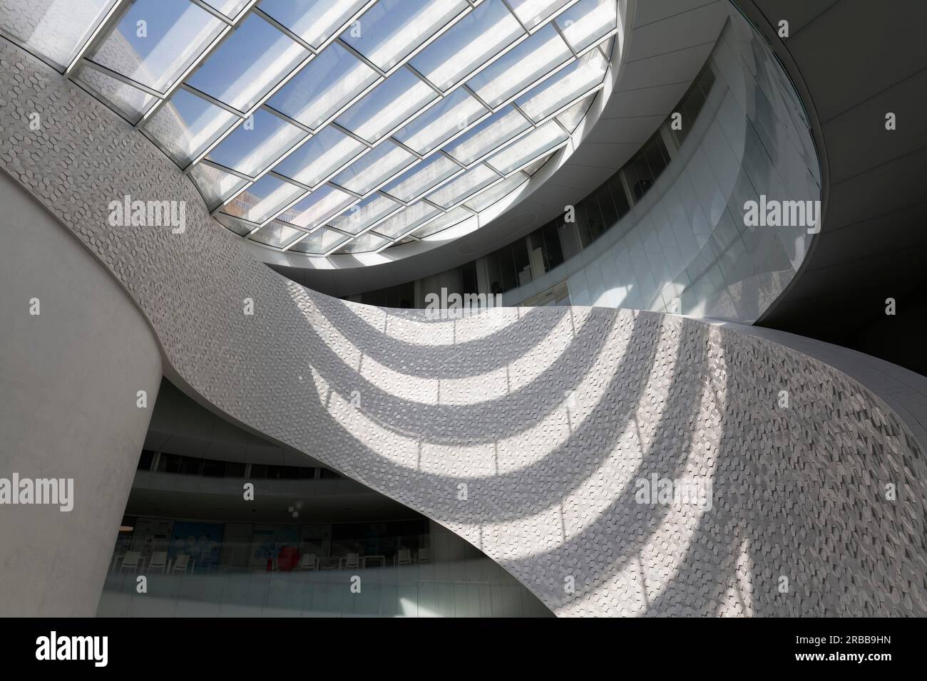 Futuristic atrium with light and shadow, walls clad in white tiles in ...
