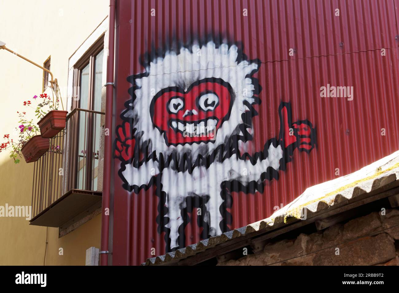 Scary figure with red face on red corrugated iron wall, graffiti ...