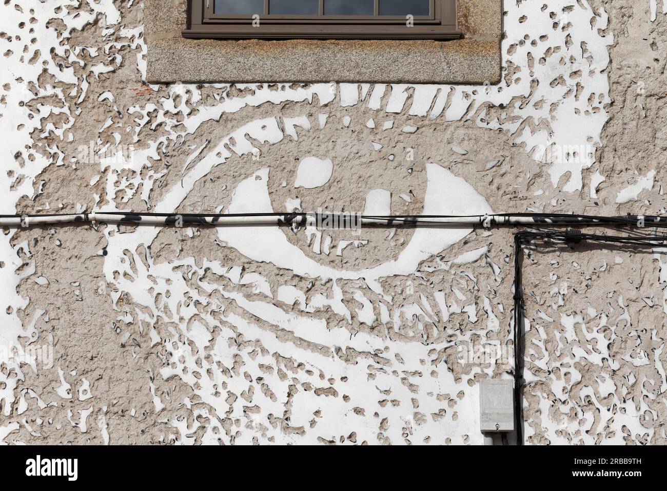 Large eye, hammered out of a house wall with a hammer and chisel, mural ...