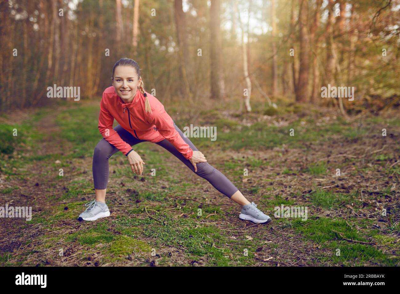 Full length portrait of a happy fit young woman doing stretching ...