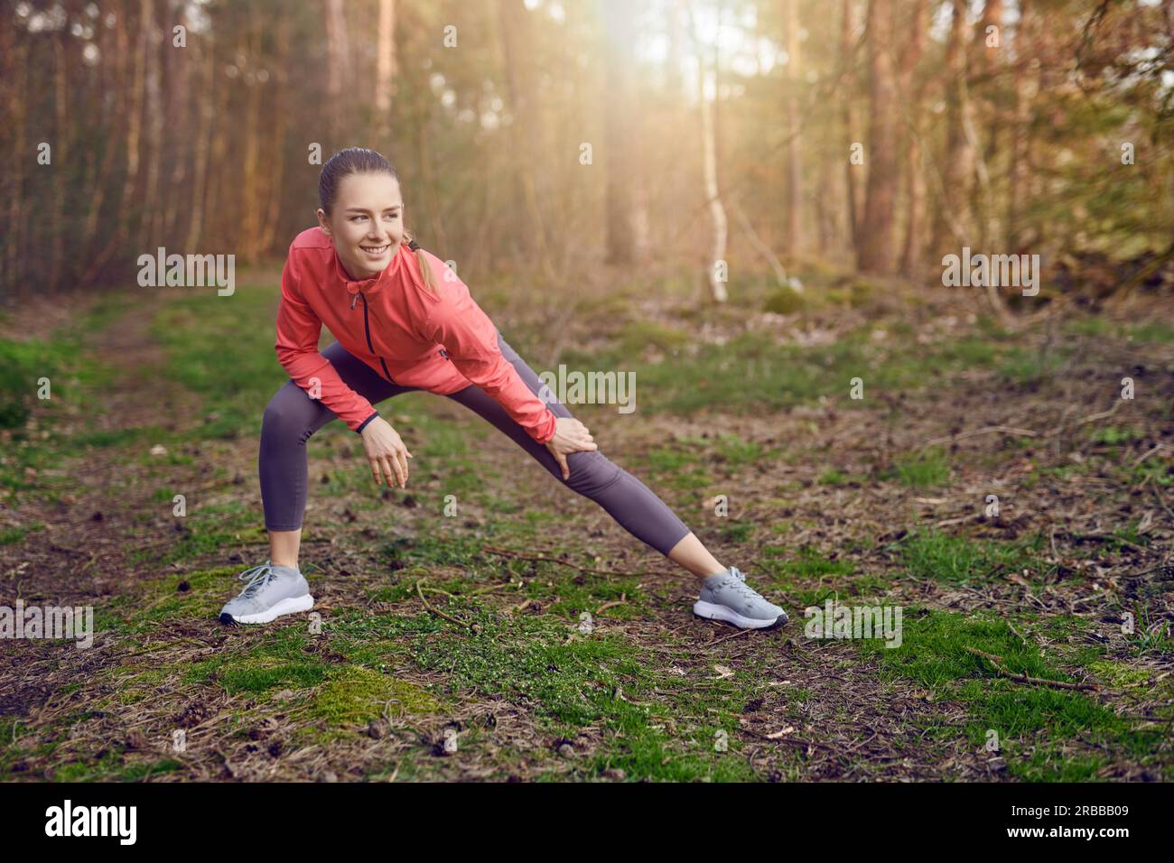 Full length portrait of a happy fit young woman doing stretching ...