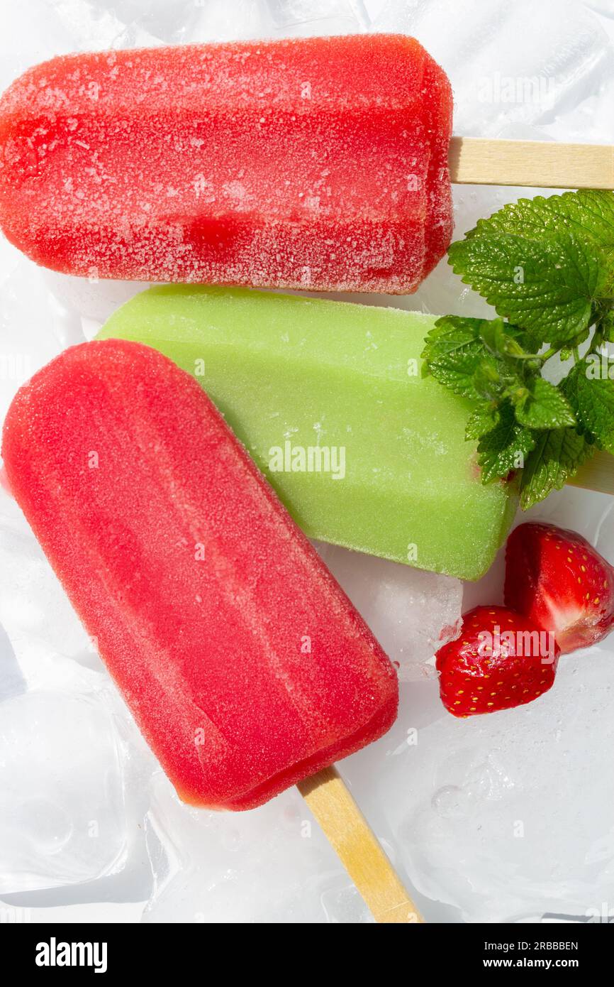 Iced ice cream of pink and light green color on a background of ice ...