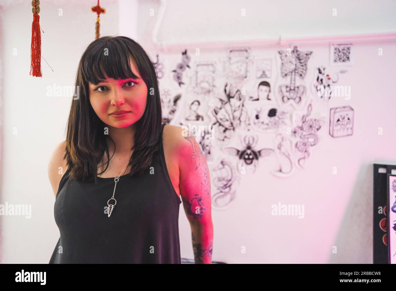 dark-haired tattooed girl in a black shirt in the tattoo salon, tattoo ...
