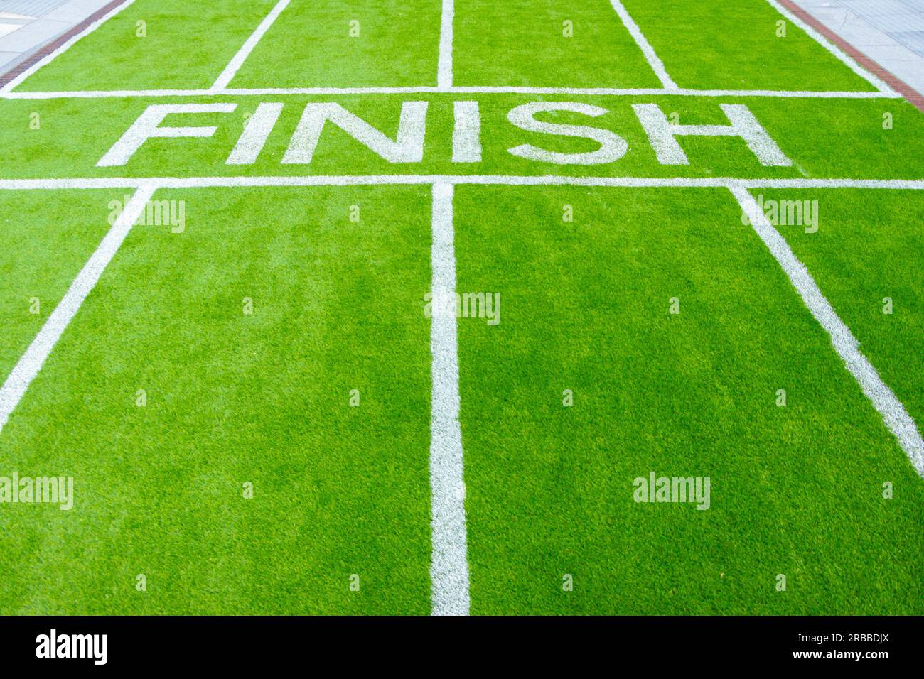 finish line concept white painted lines running race track on grass at ...