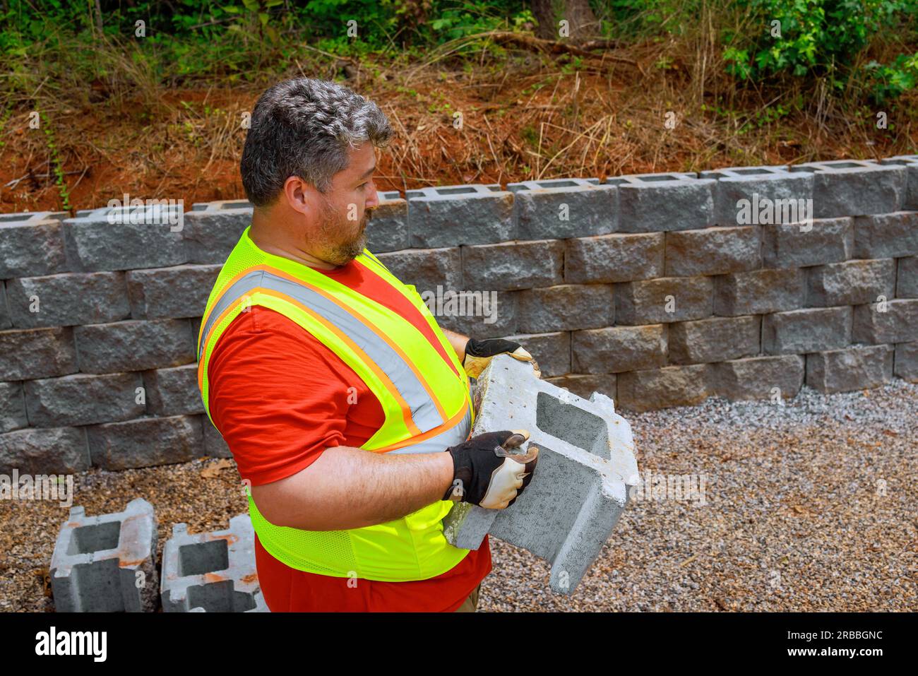 Construction worker lifted concrete block before mounting it on ...