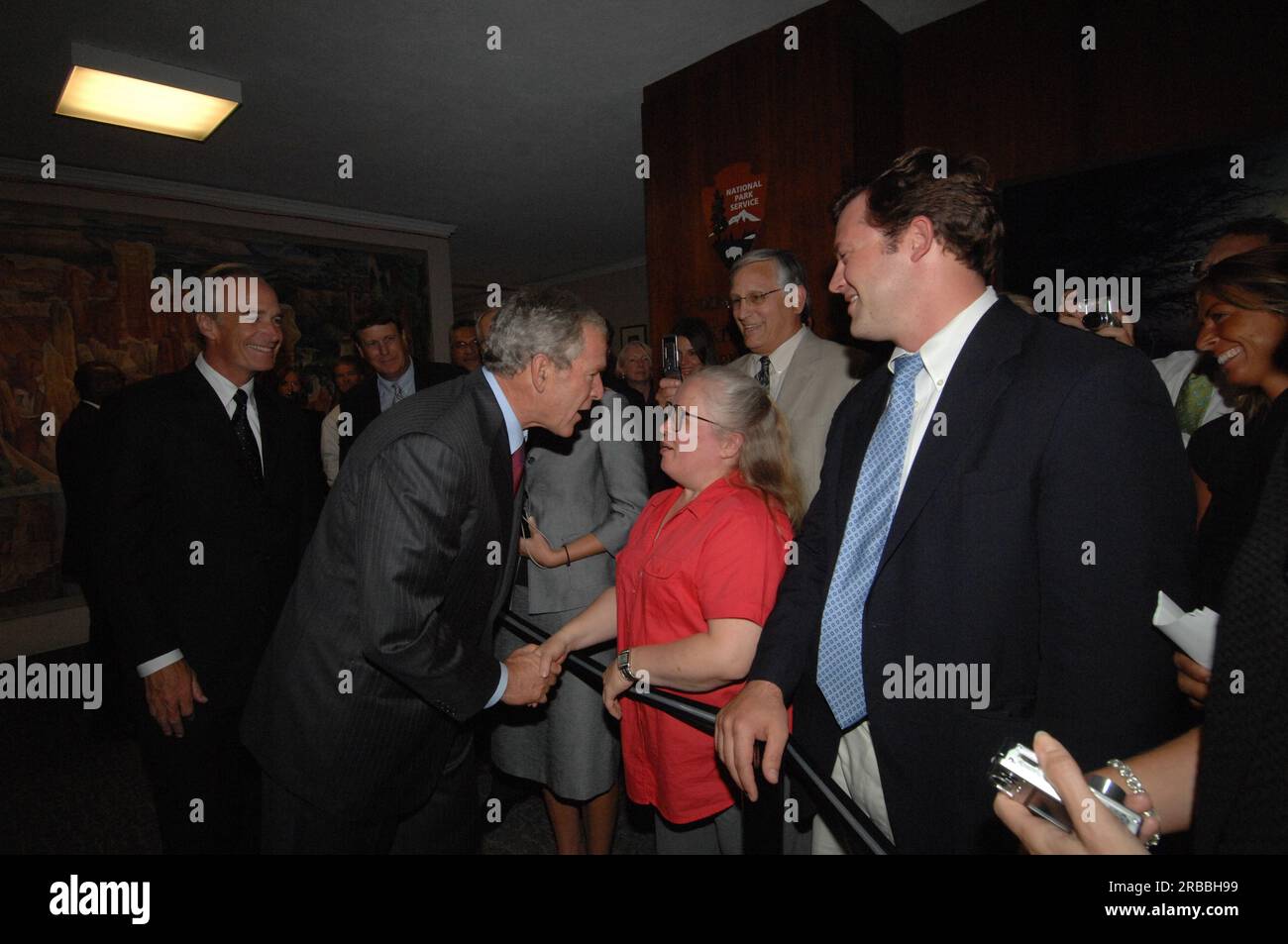 Department staff greeting President George W. Bush, from behind rope ...