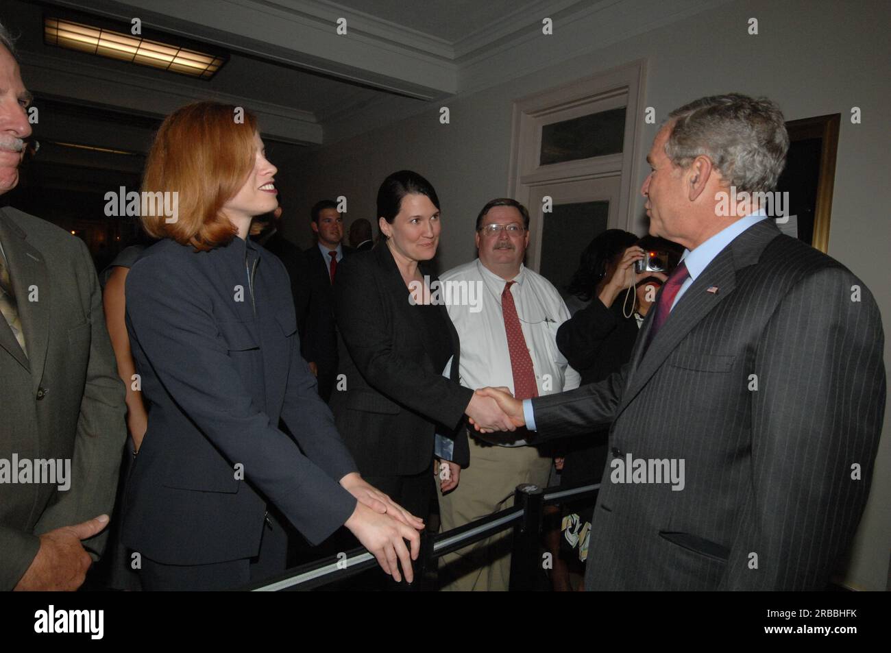 Department staff greeting President George W. Bush, from behind rope ...