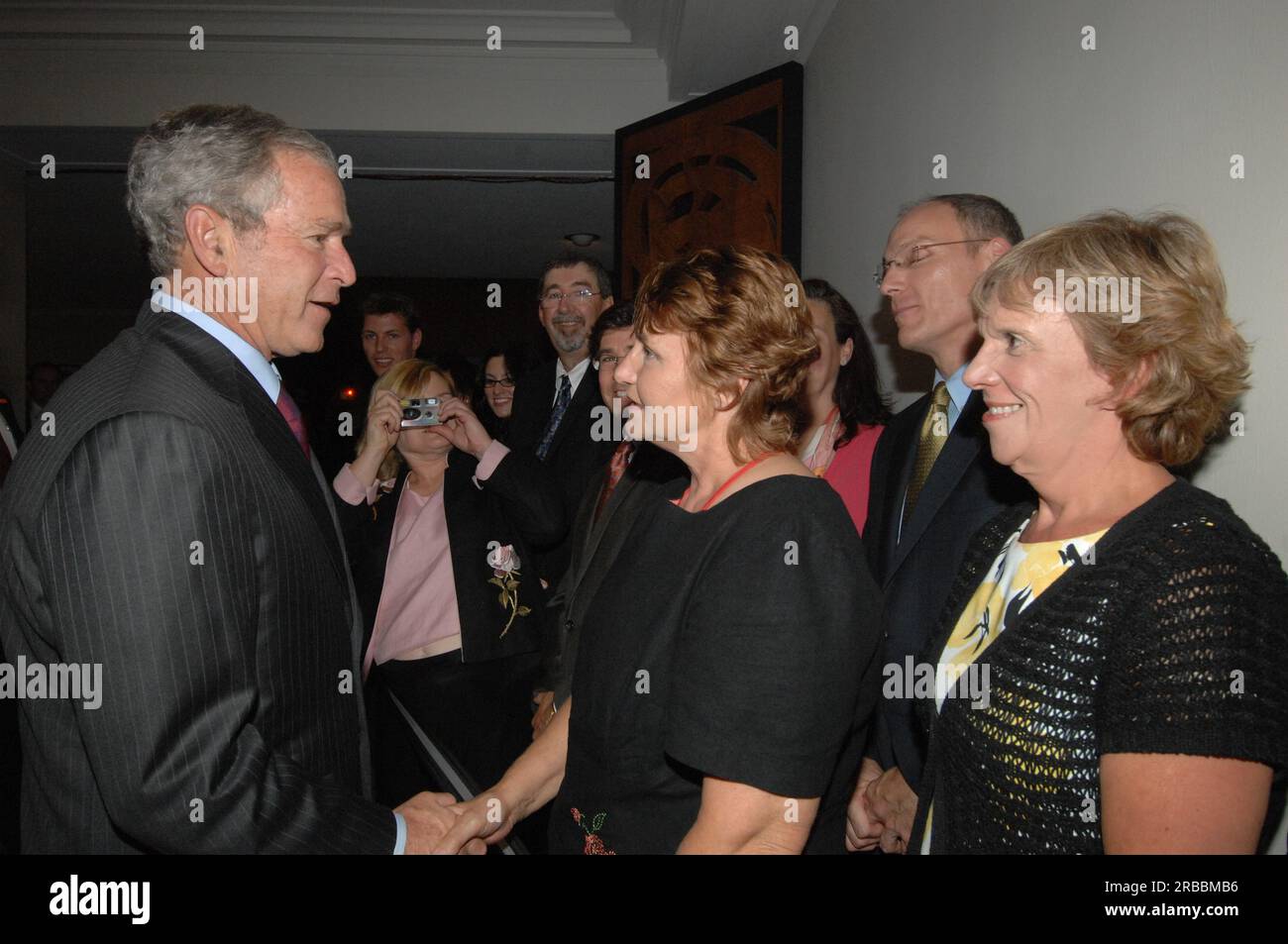 Department staff greeting President George W. Bush, from behind rope ...