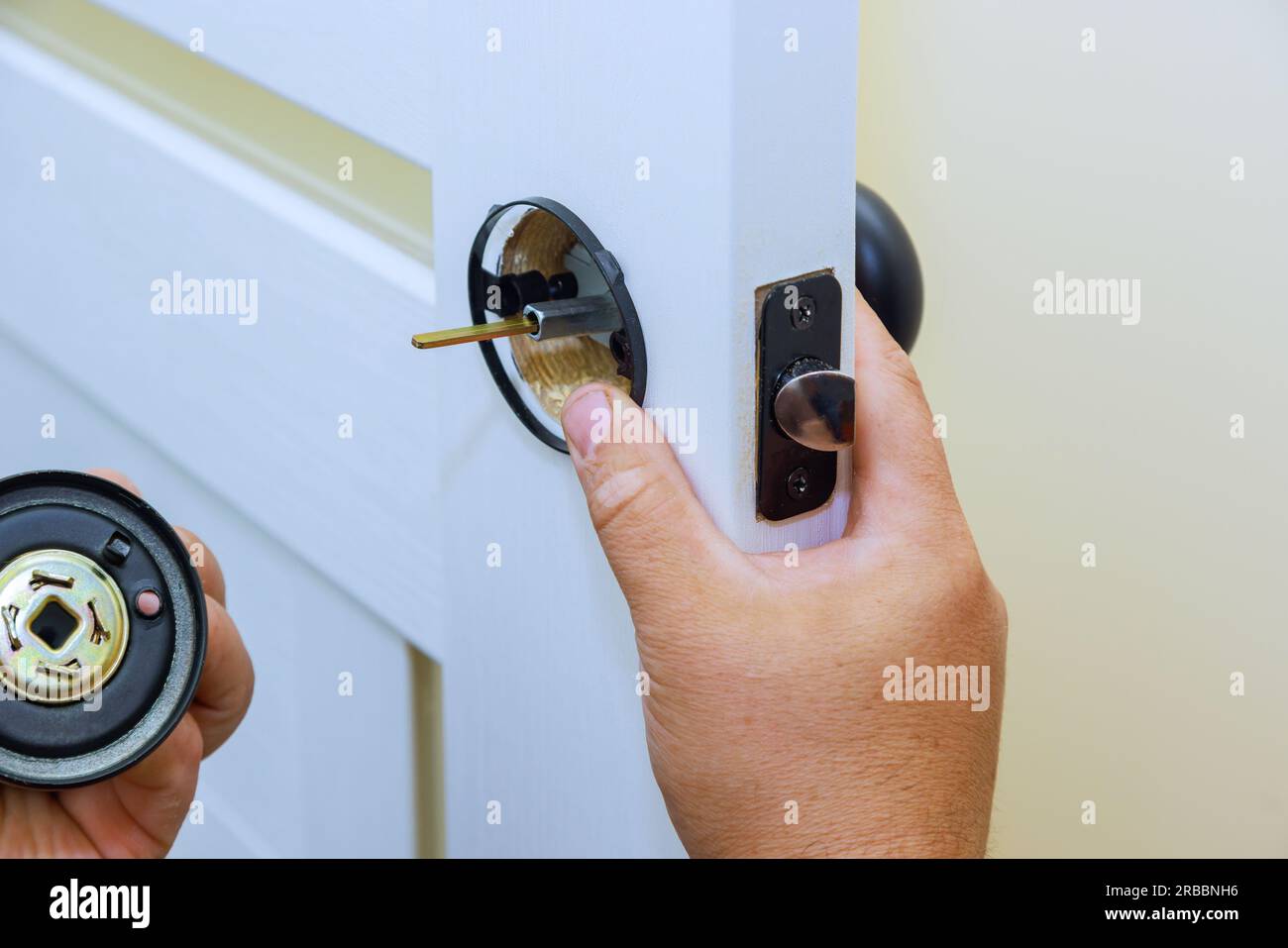 With worker attaches lock to new interior door Stock Photo - Alamy