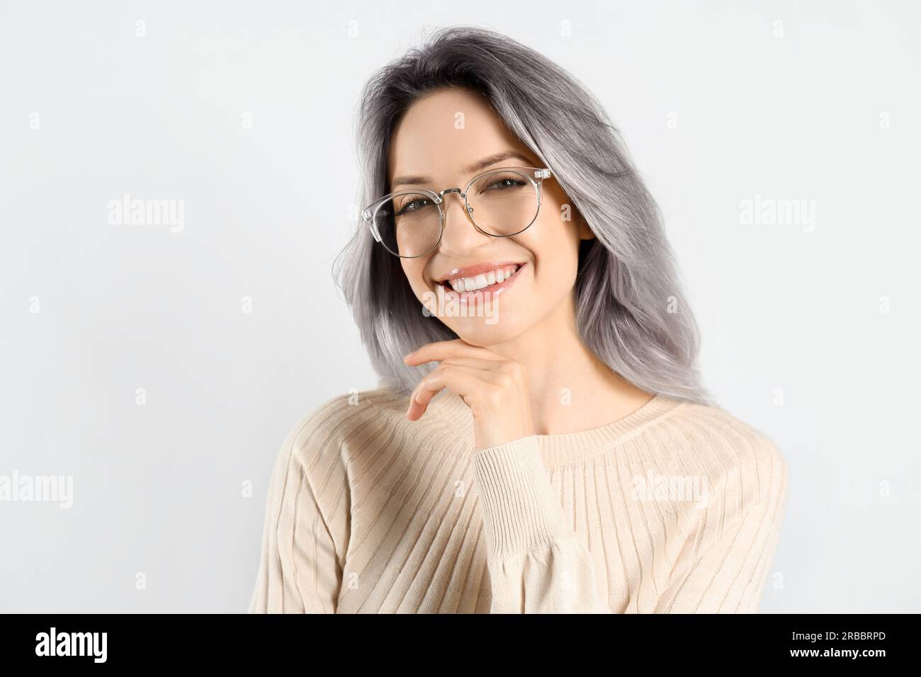 Portrait of smiling woman with ash hair color on light background Stock ...