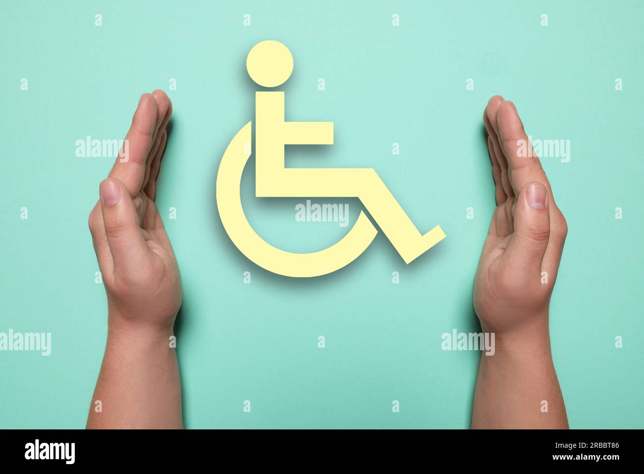 Disability inclusion. Woman protecting wheelchair symbol on turquoise ...