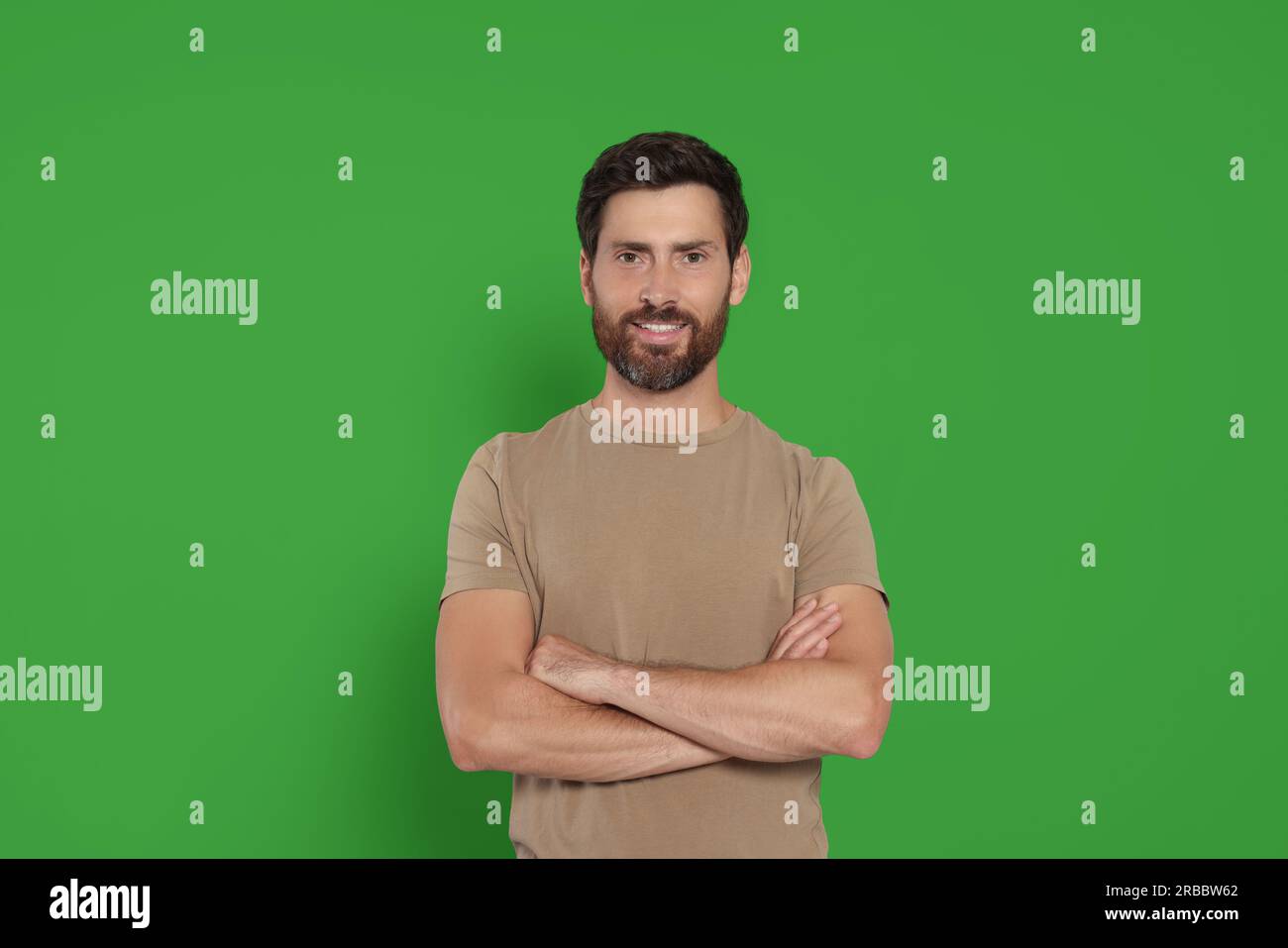 Chroma key compositing. Handsome man smiling against green screen Stock ...