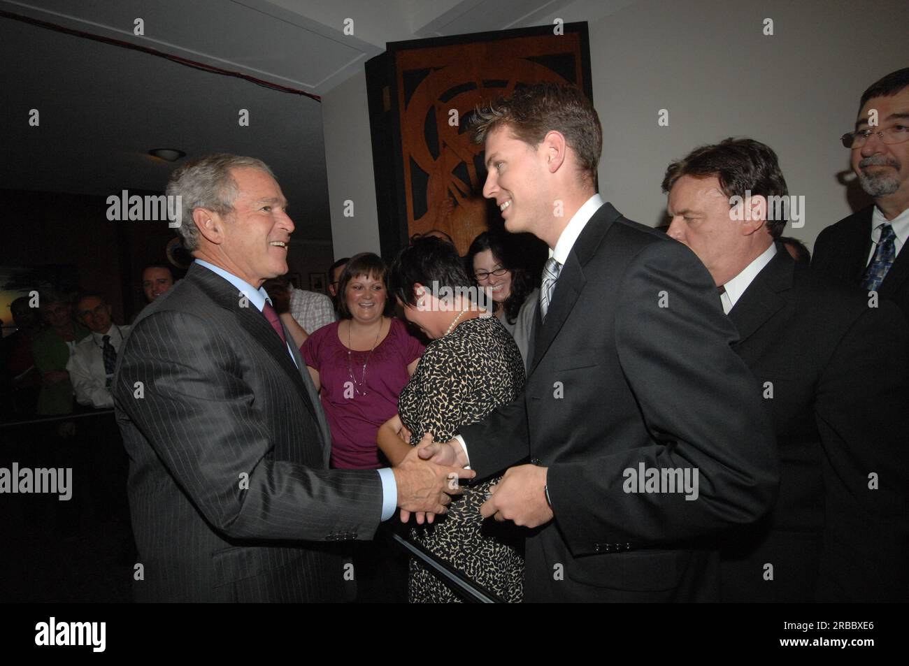 Department staff greeting President George W. Bush, from behind rope ...