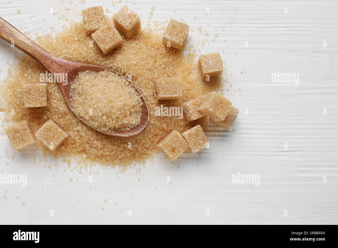 Different types of brown sugar on white wooden table, top view. Space ...