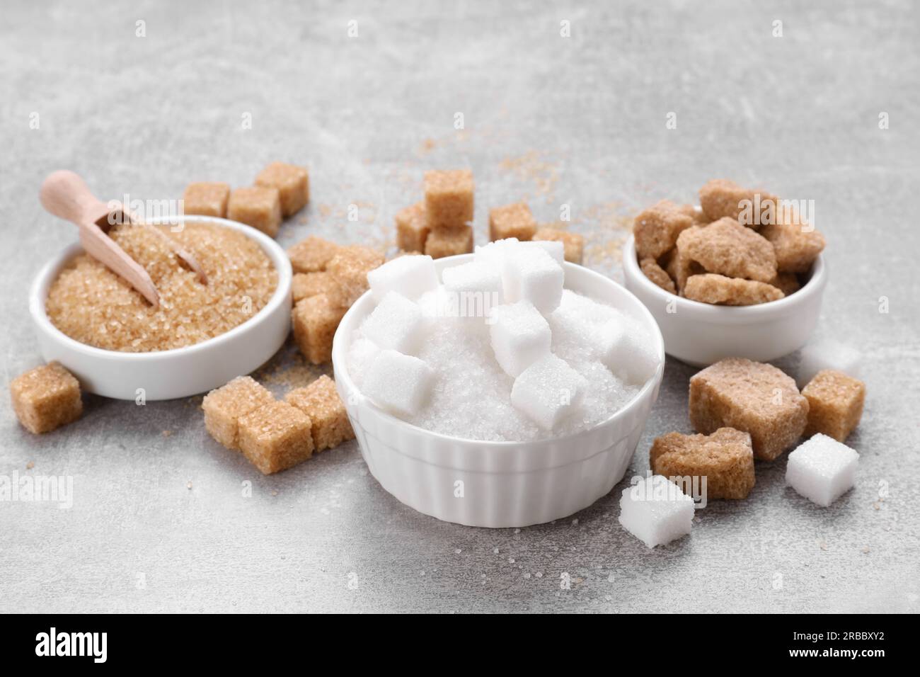 Different types of sugar on grey table Stock Photo - Alamy