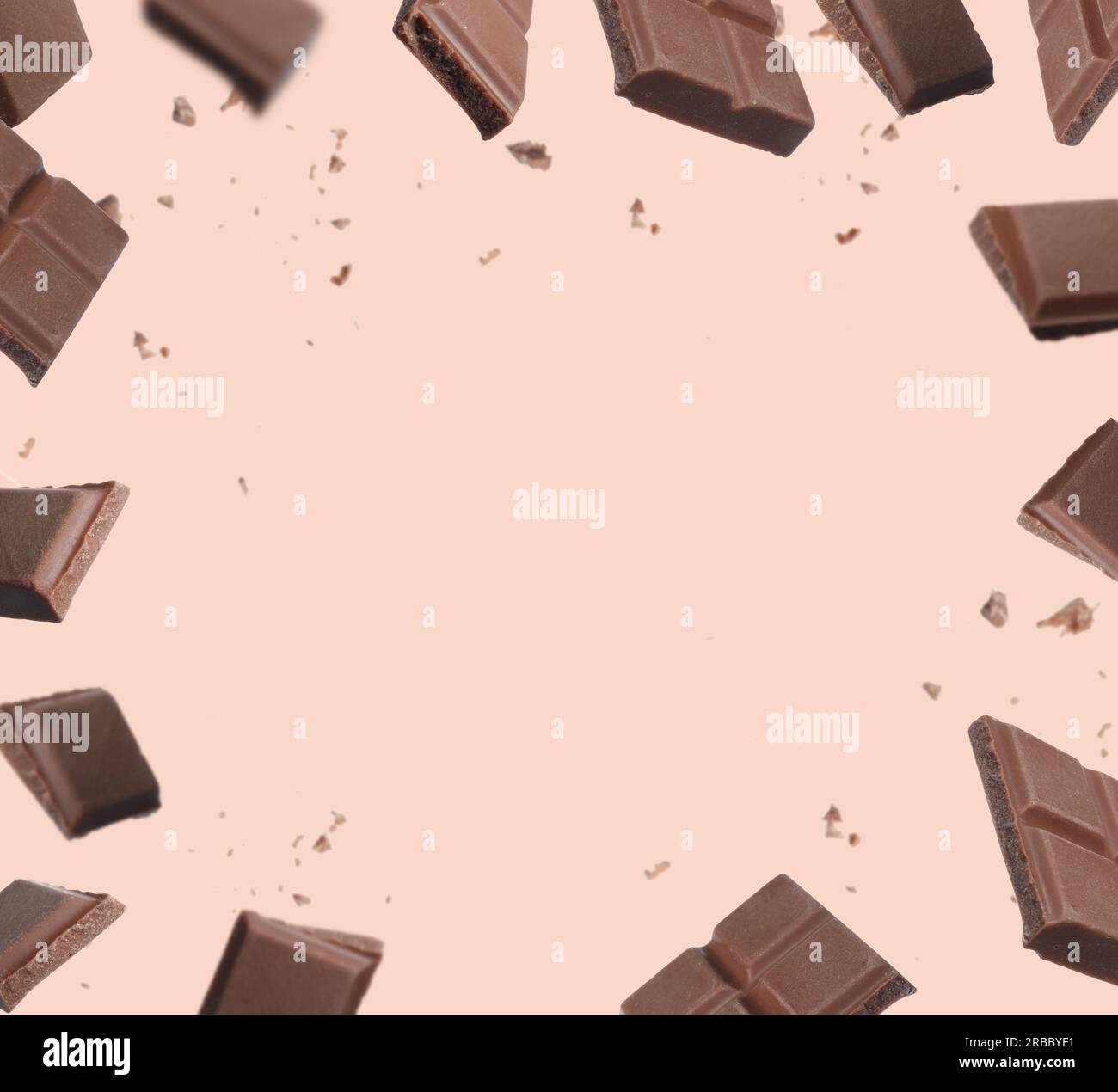 Frame of falling pieces of chocolate bar on beige background, space for ...