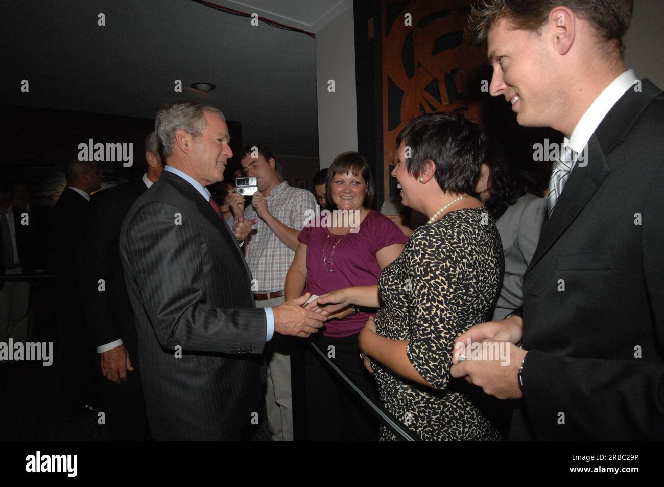 Department staff greeting President George W. Bush, from behind rope ...