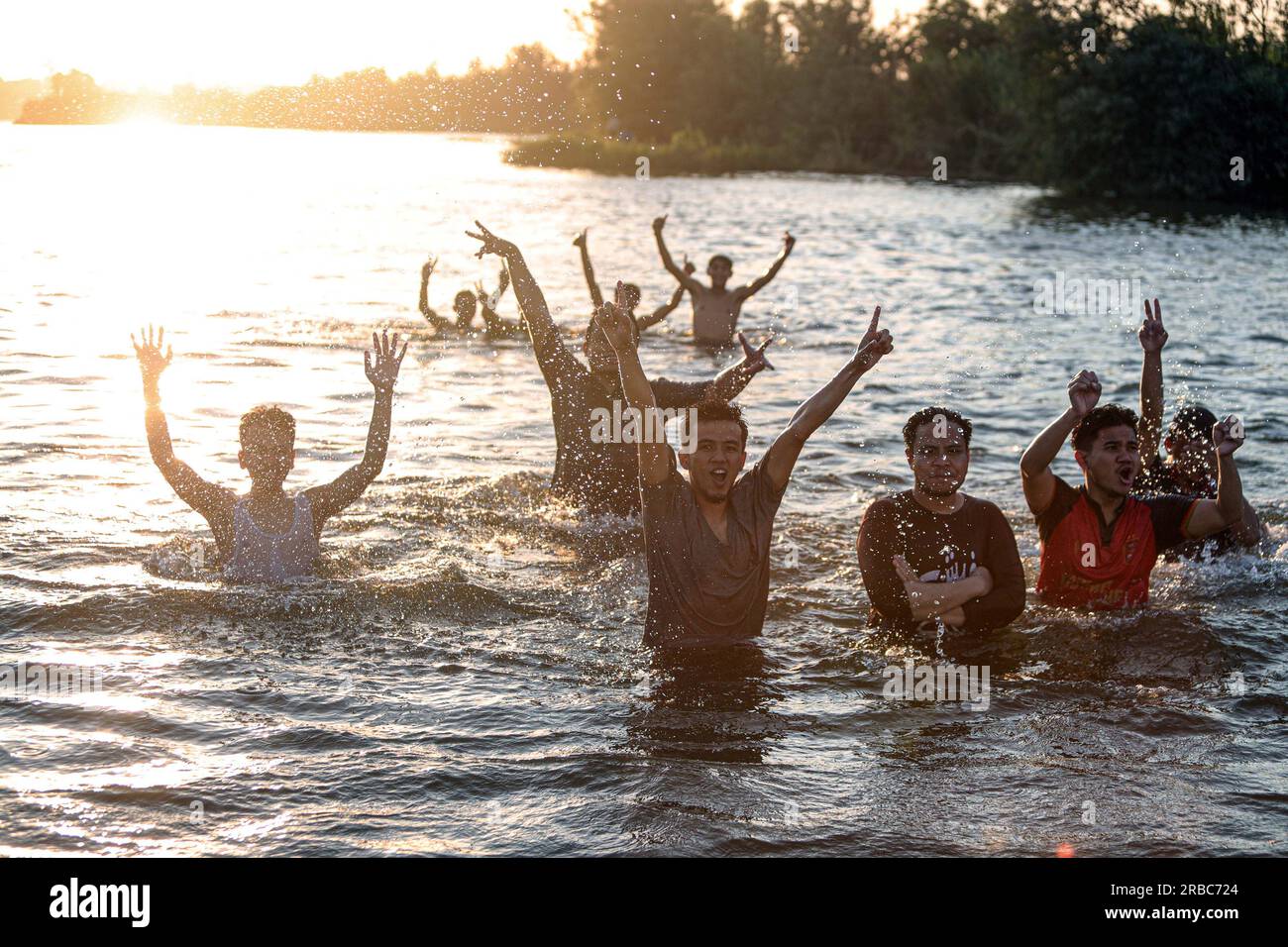 Qalyubia, Egypt. 8th July, 2023. People play in the Nile to cool off in ...