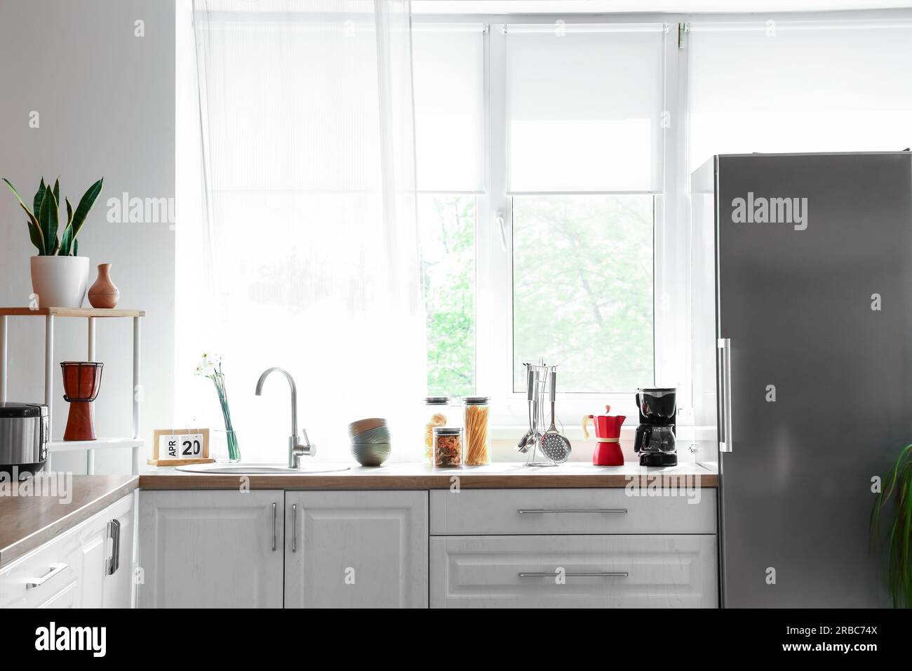 Interior of kitchen with stylish fridge, counters and window Stock ...