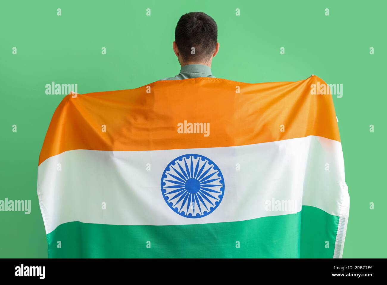 Young man with Indian flag on green background, back view Stock Photo ...