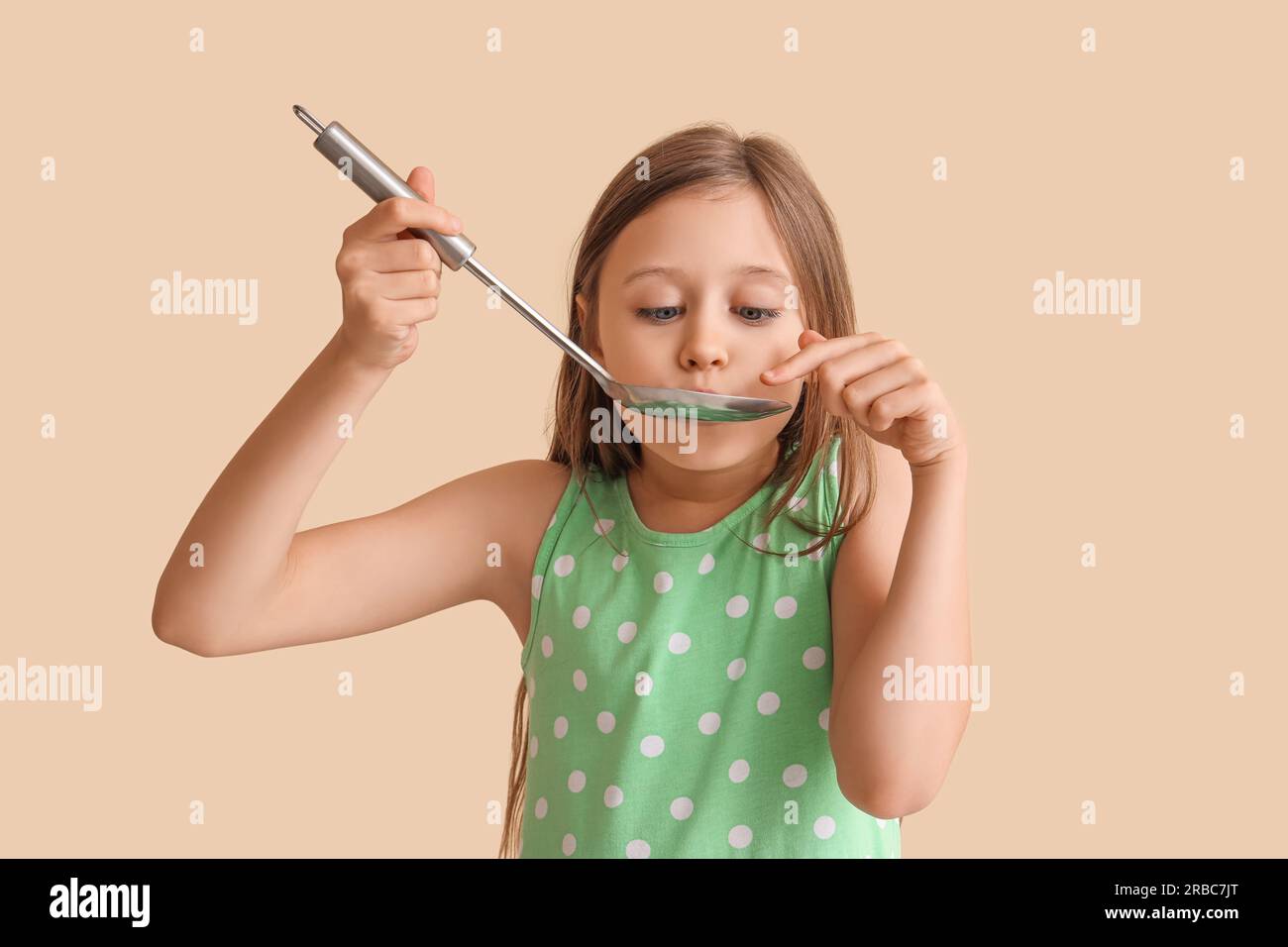 Little girl with ladle on beige background Stock Photo - Alamy