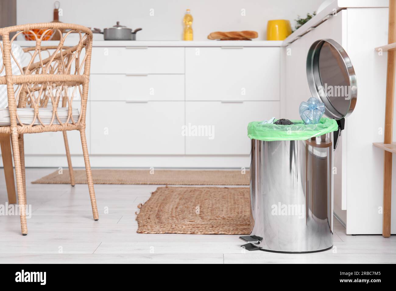 Opened trash bin with garbage in interior of light kitchen Stock Photo ...