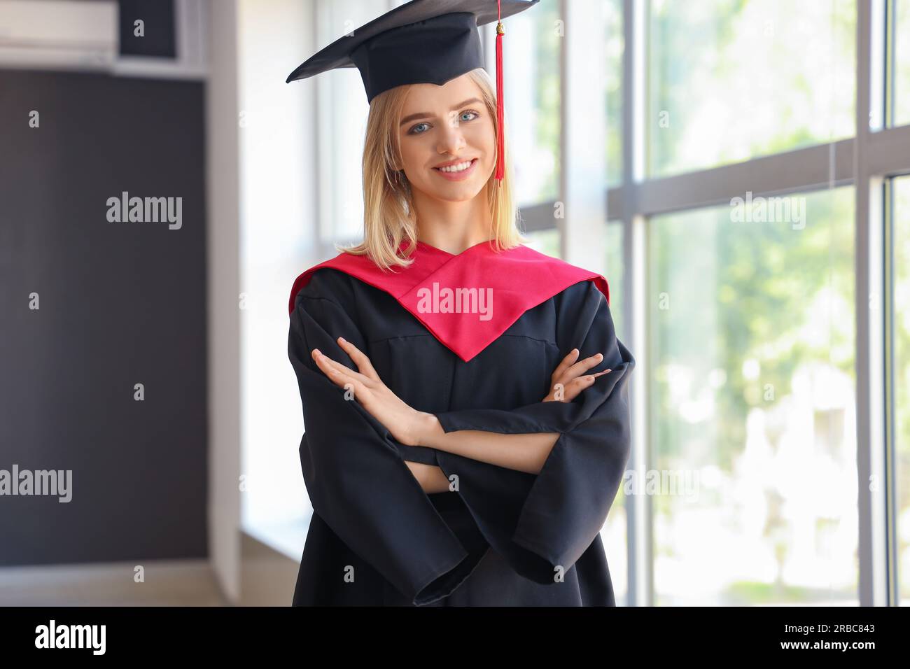 Female graduate student near window in room Stock Photo - Alamy