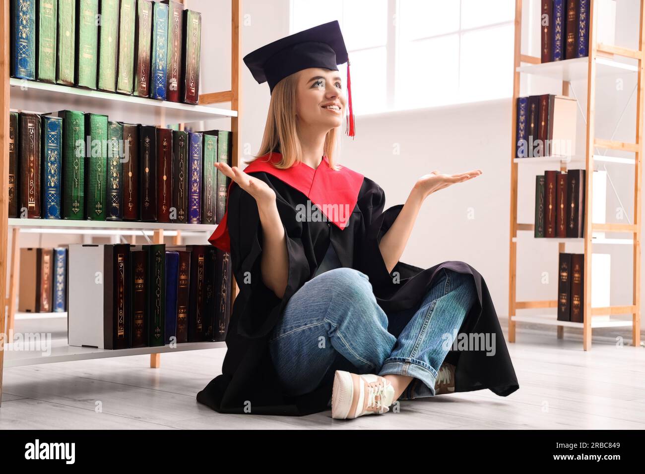 Female graduate student sitting in library Stock Photo - Alamy