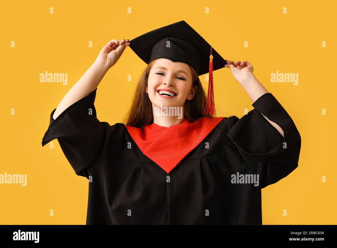 Female graduate student on yellow background Stock Photo - Alamy