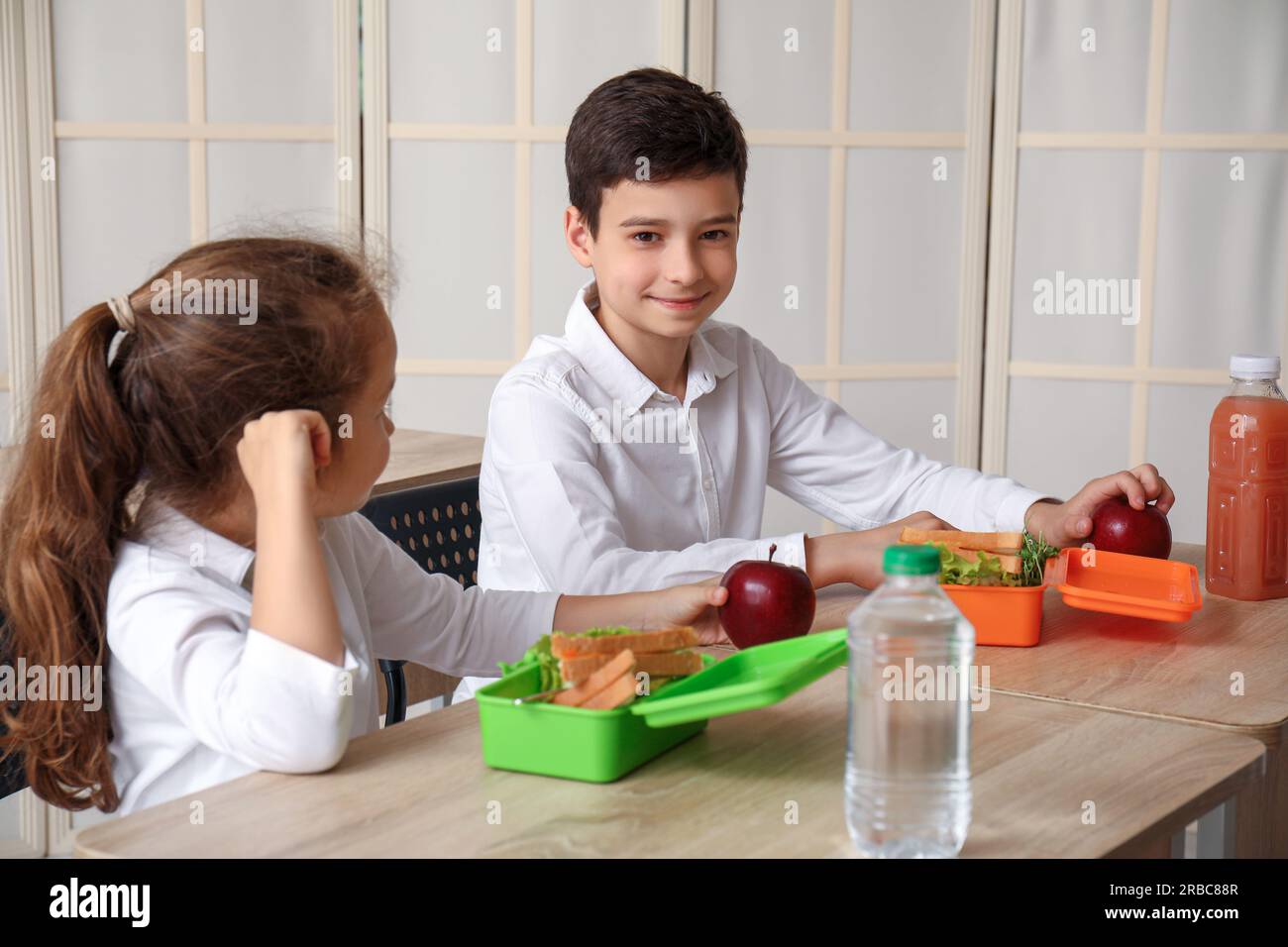 Little children eating lunch in classroom Stock Photo - Alamy