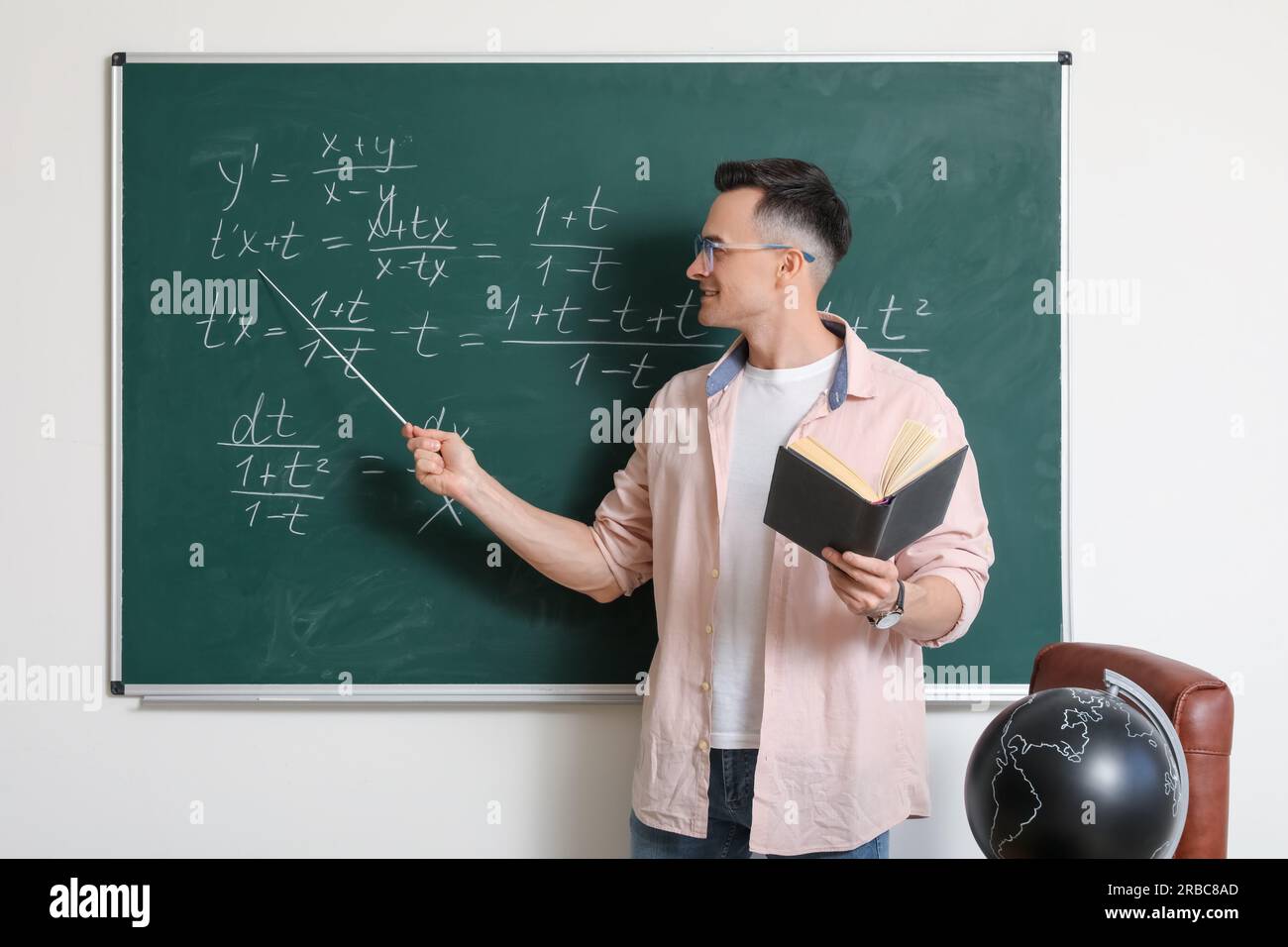 Male Math teacher conducting lesson near chalkboard in classroom Stock ...