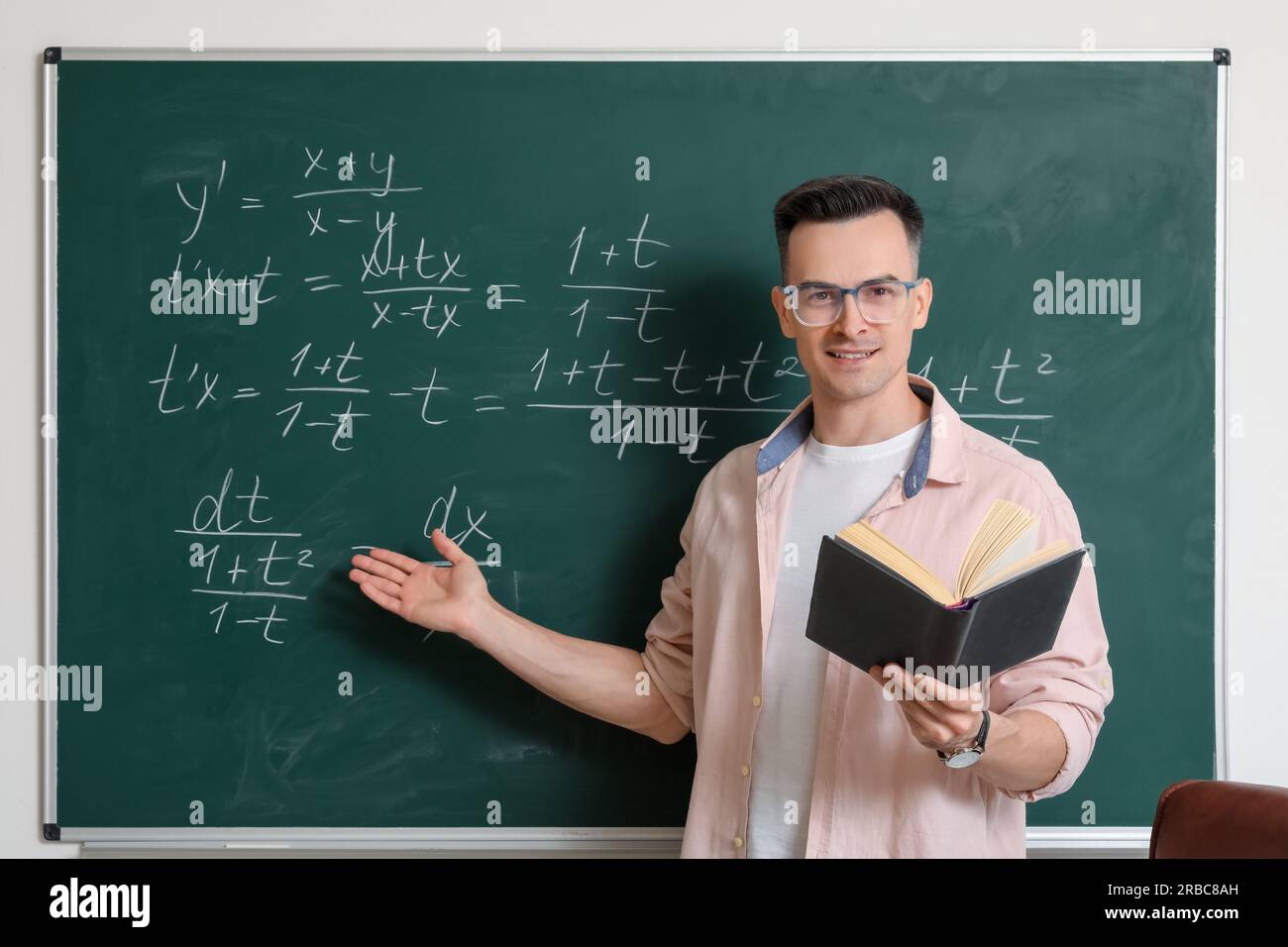 Male Math teacher conducting lesson near chalkboard in classroom Stock ...