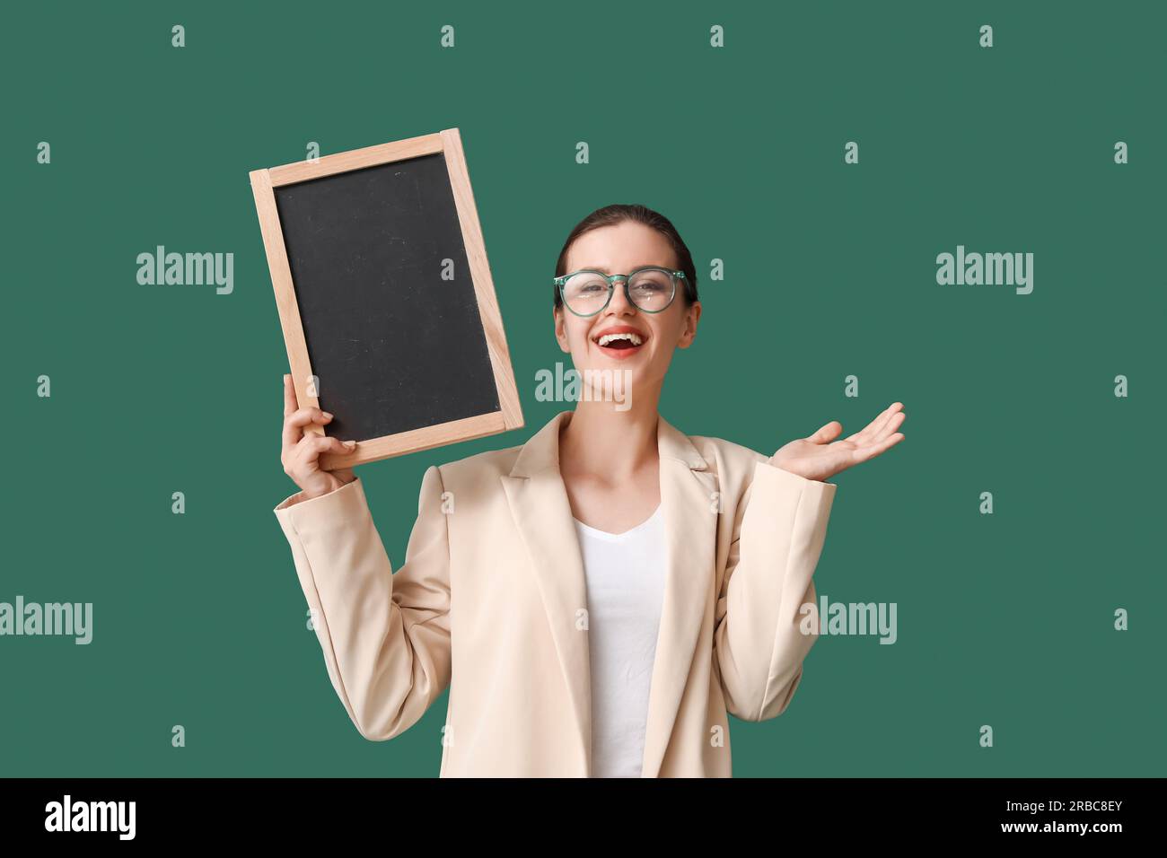 Female teacher with chalkboard on green background Stock Photo - Alamy