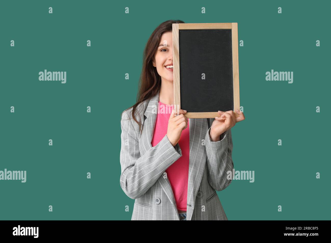 Female teacher with chalkboard on green background Stock Photo - Alamy